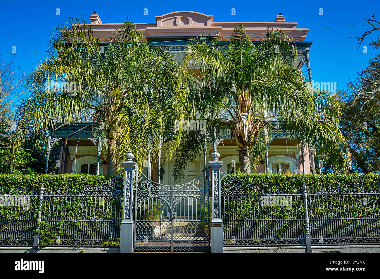 A decorative wrought iron fence & gate surrounds an historical mansion ...