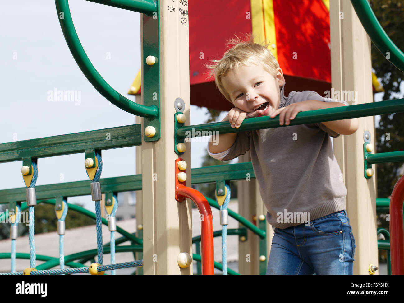 Boy on playground equipment Stock Photo - Alamy
