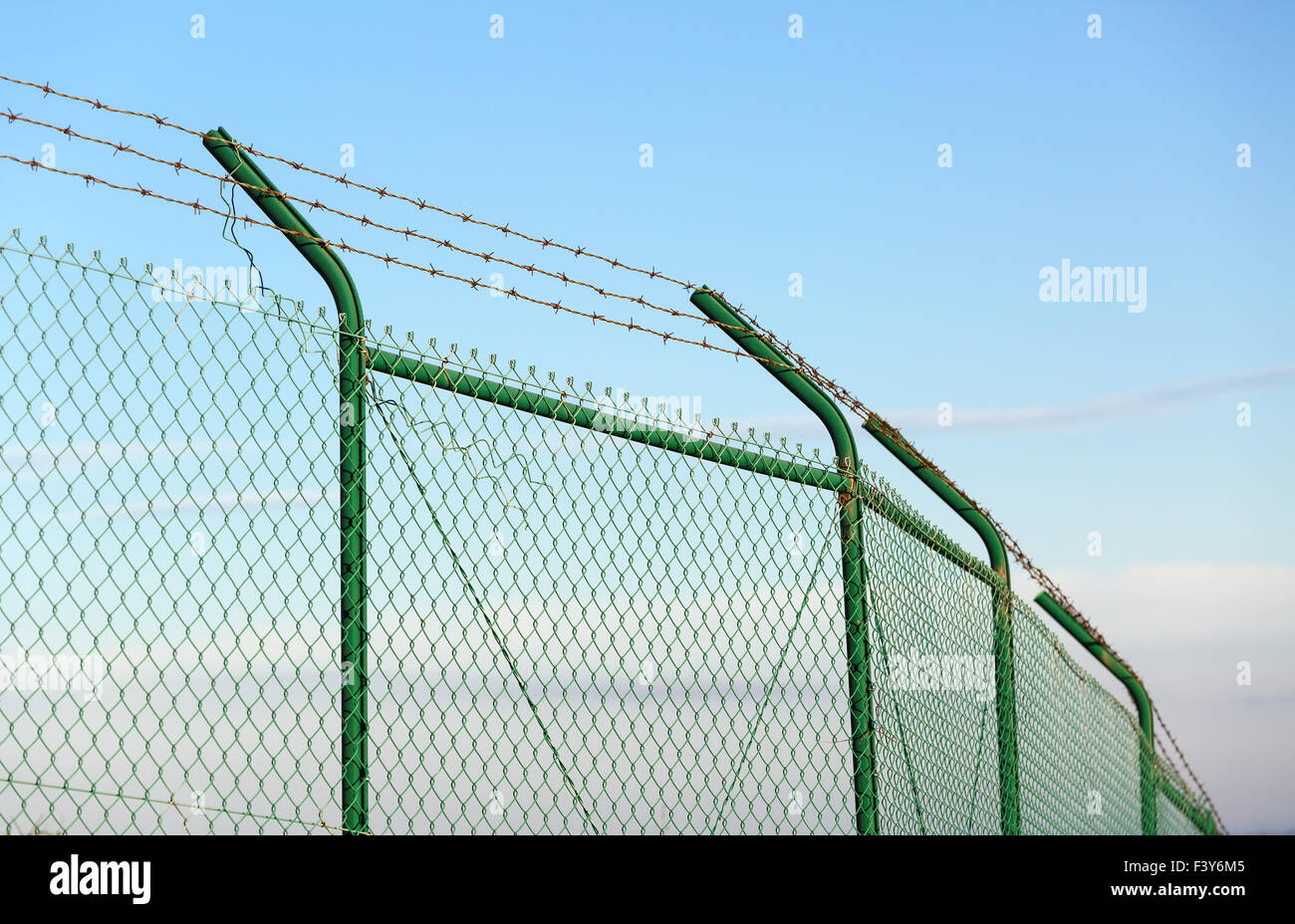 Mesh fence with barbed wire Stock Photo - Alamy