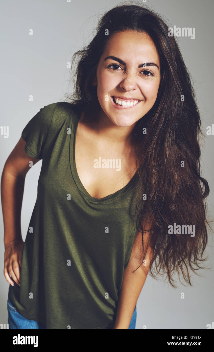 Cute casual young woman in a tee shirt with long brunette hair leaning ...