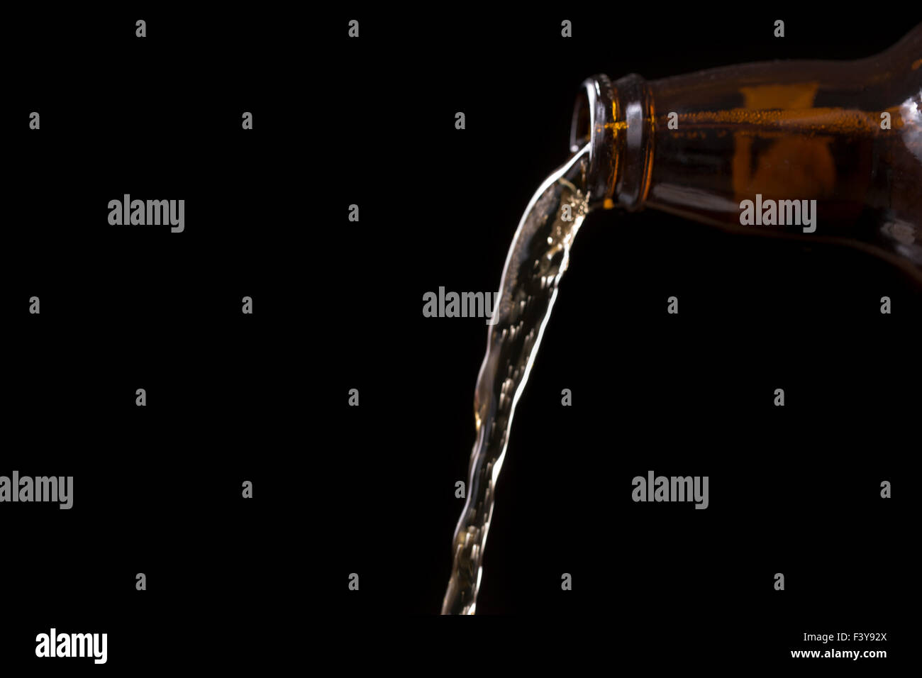 Beer Pouring From Bottle with black background Stock Photo - Alamy