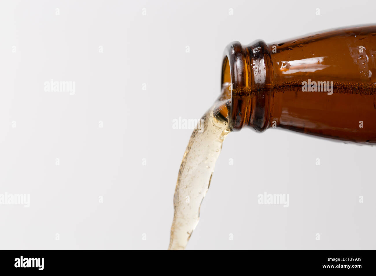 Beer Puring From Bottle with grey/white background with bubbles in the ...