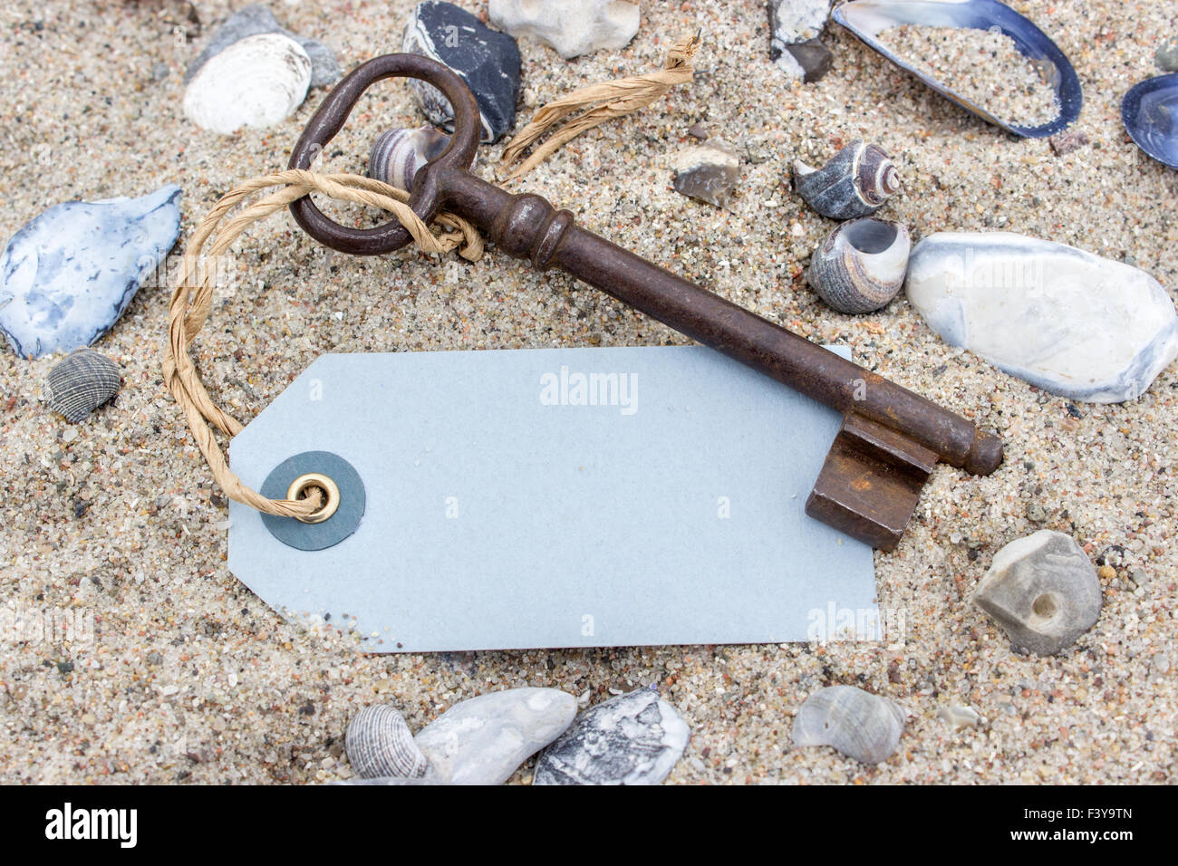 Old key with key chain in the sand Stock Photo - Alamy