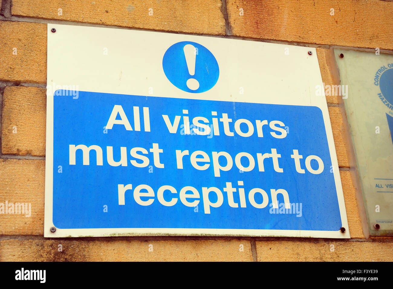 An instruction sign at a car dealership requesting all visitors to ...