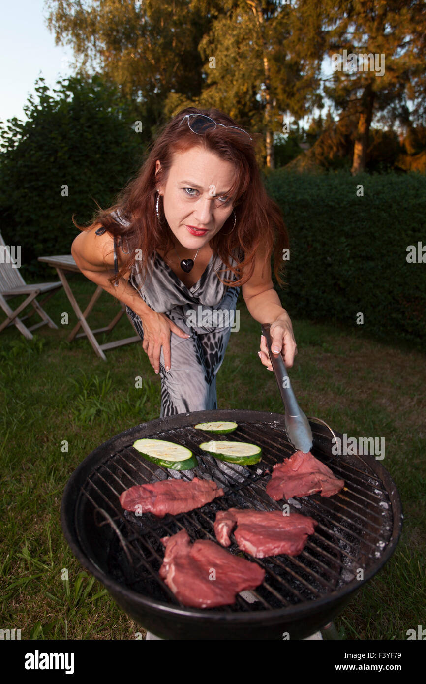 Woman cooking over grill hi-res stock photography and images - Alamy