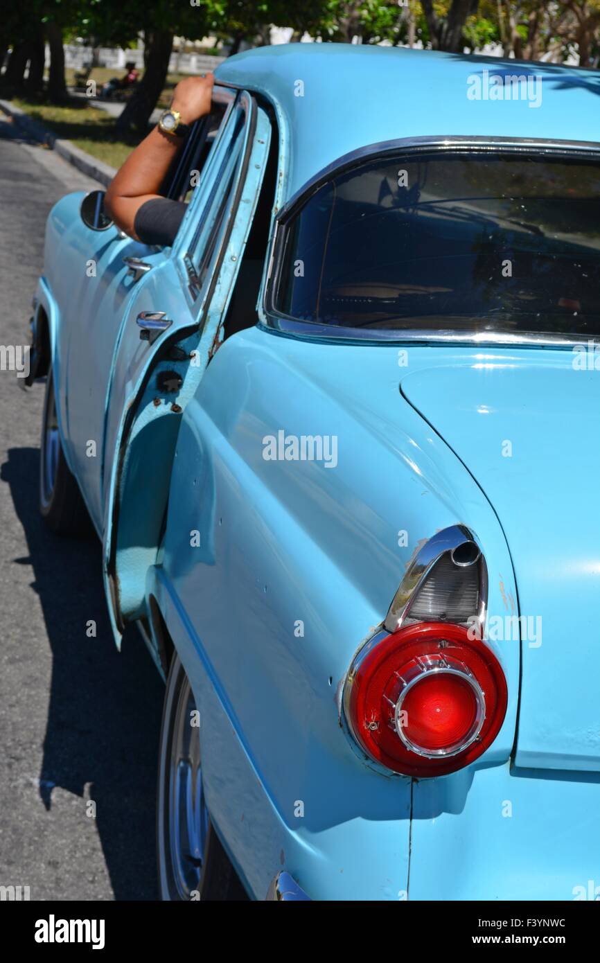 detail of rear view of parked blue vintage taxi with red tail light and ...
