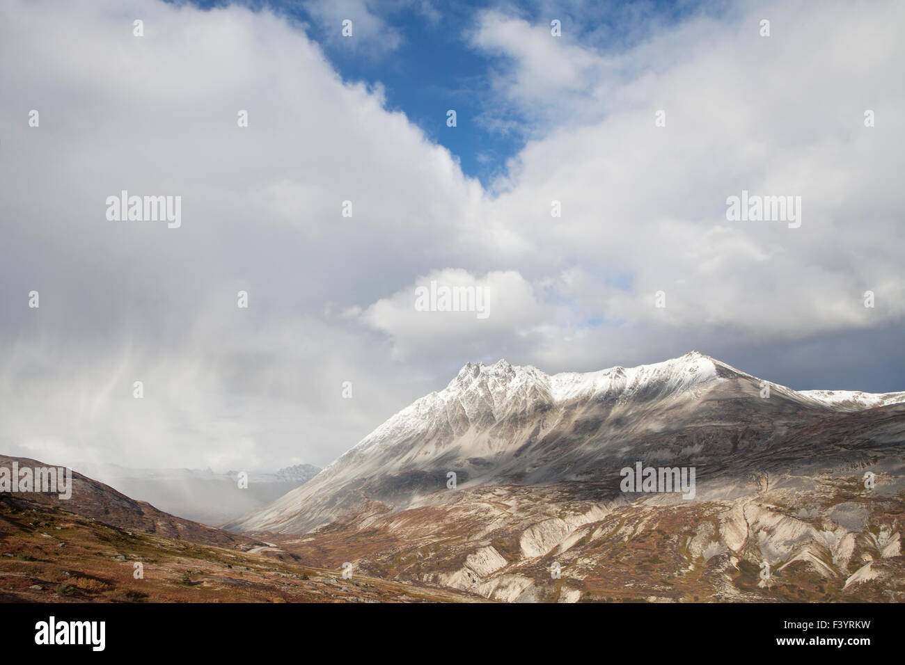Storm clouds part to reveal sun on mountain peaks in high elevation ...