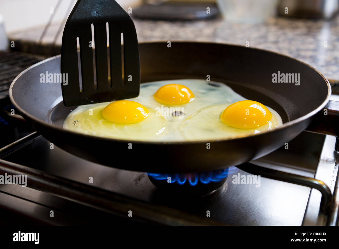 Fried eggs being cooked Stock Photo - Alamy