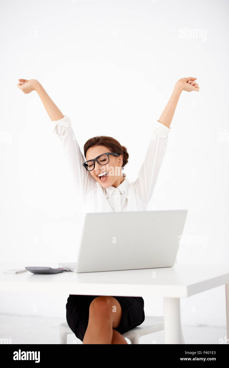 Young accountant at her desk with raised arms Stock Photo - Alamy