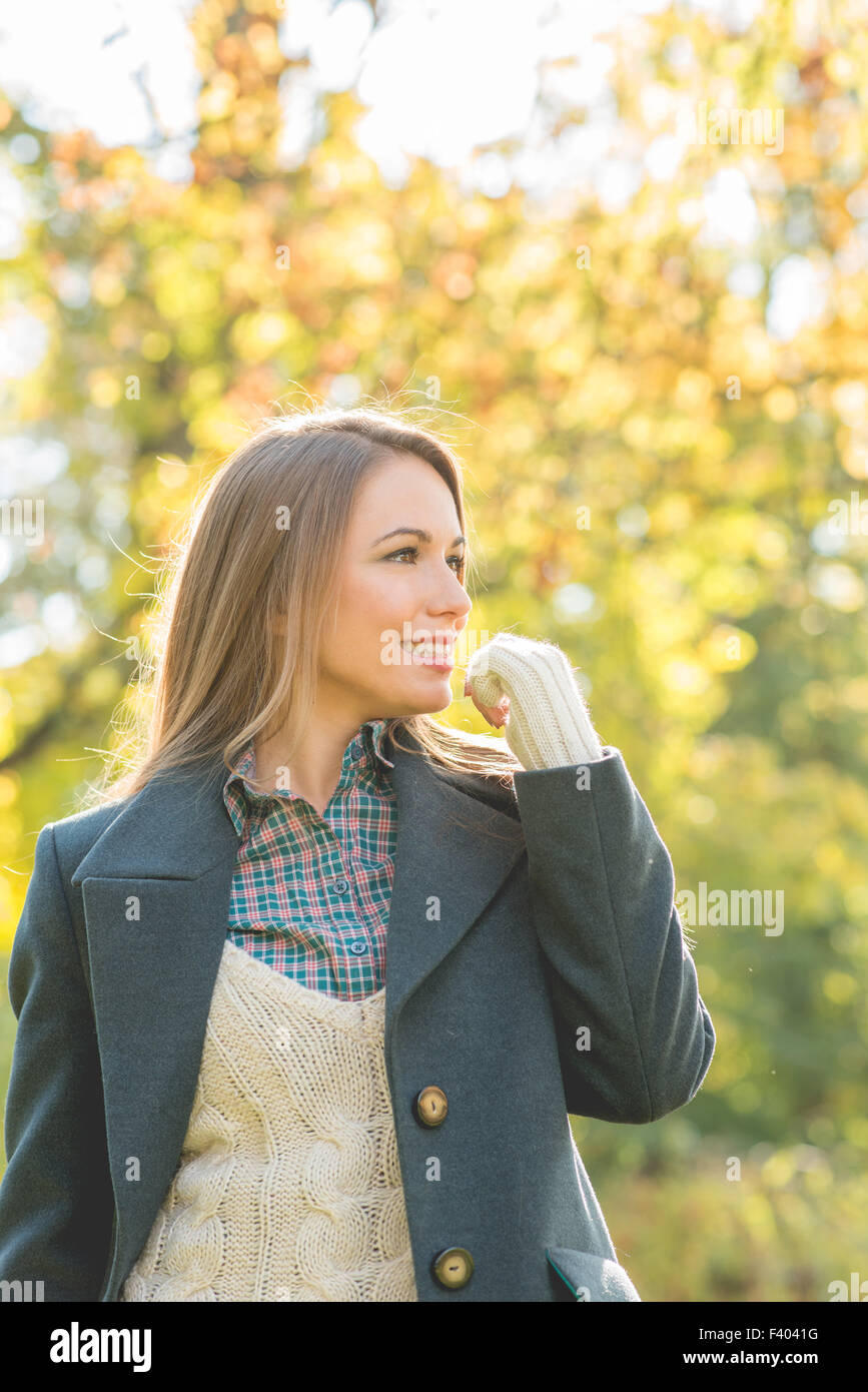 Attractive woman standing thinking Stock Photo - Alamy