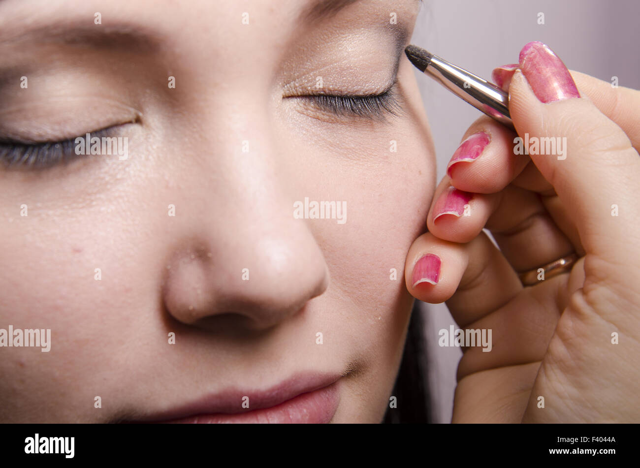 Makeup artist colors upper eyelids model Stock Photo - Alamy