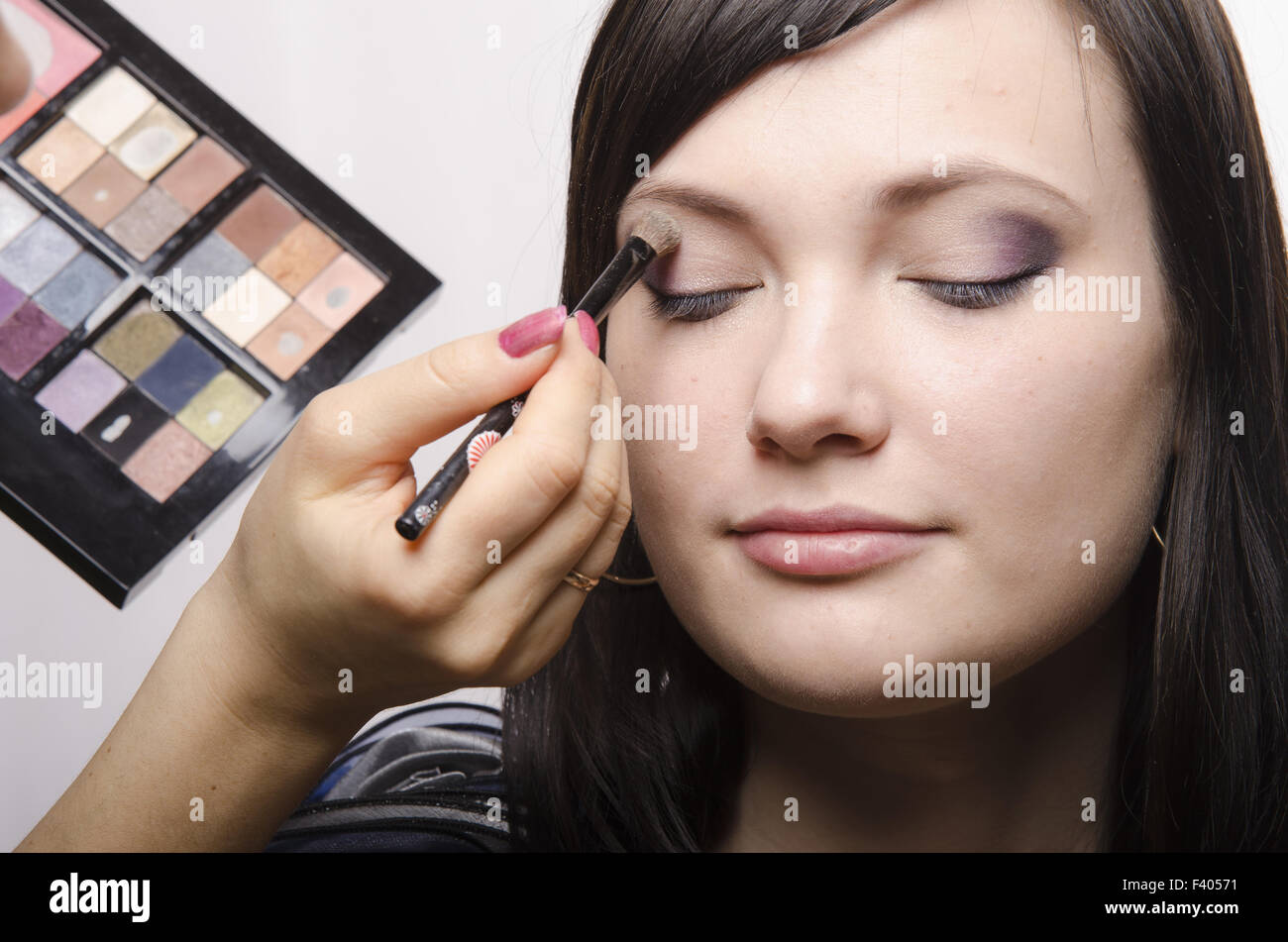 Makeup artist colors upper eyelids model Stock Photo - Alamy