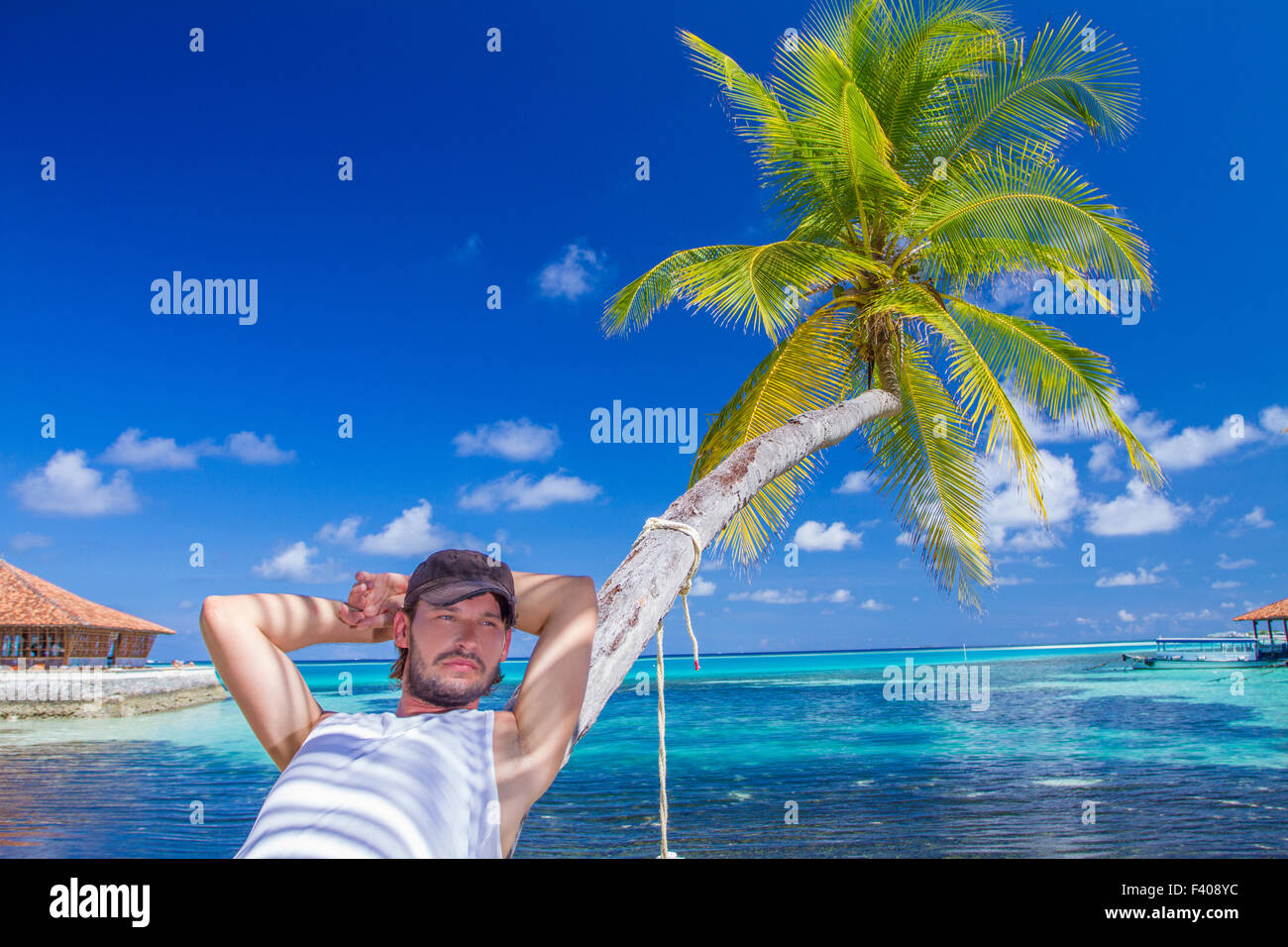 Gorgeous Man Resting on Beach Palm Tree Stock Photo - Alamy