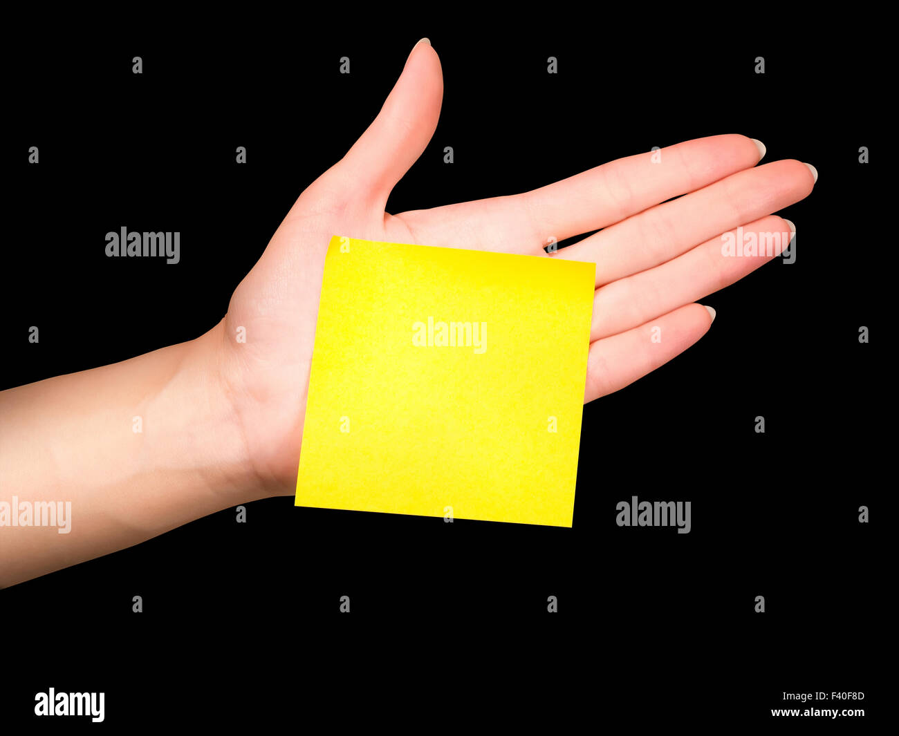 Hand with yellow blank note stick isolated on black with clipping path ...