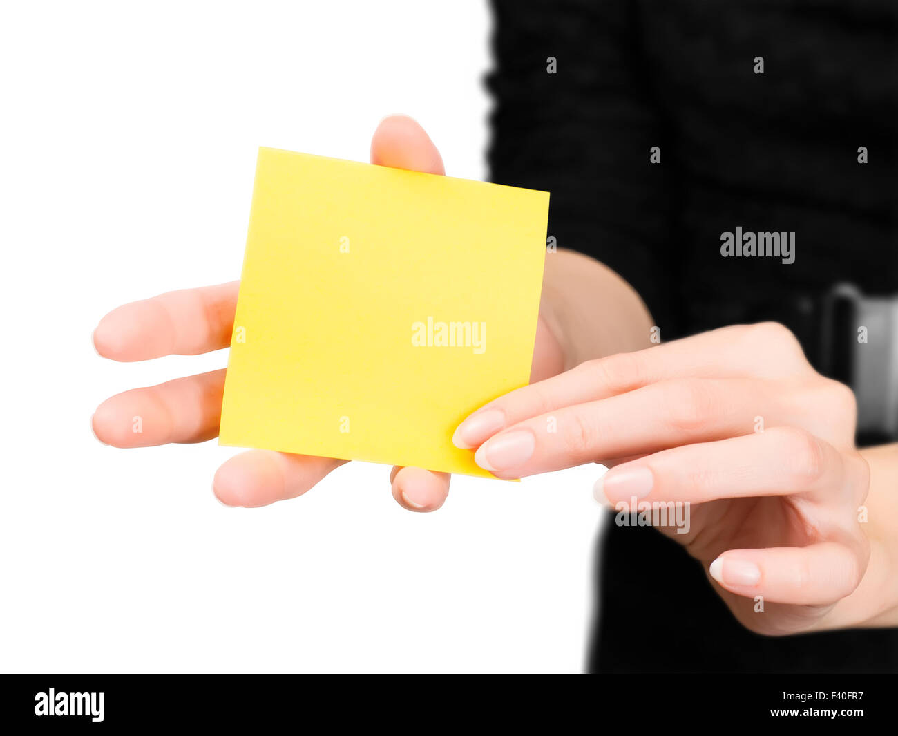 Beautiful woman hands with blurred silhouette holding blank yellow memo ...