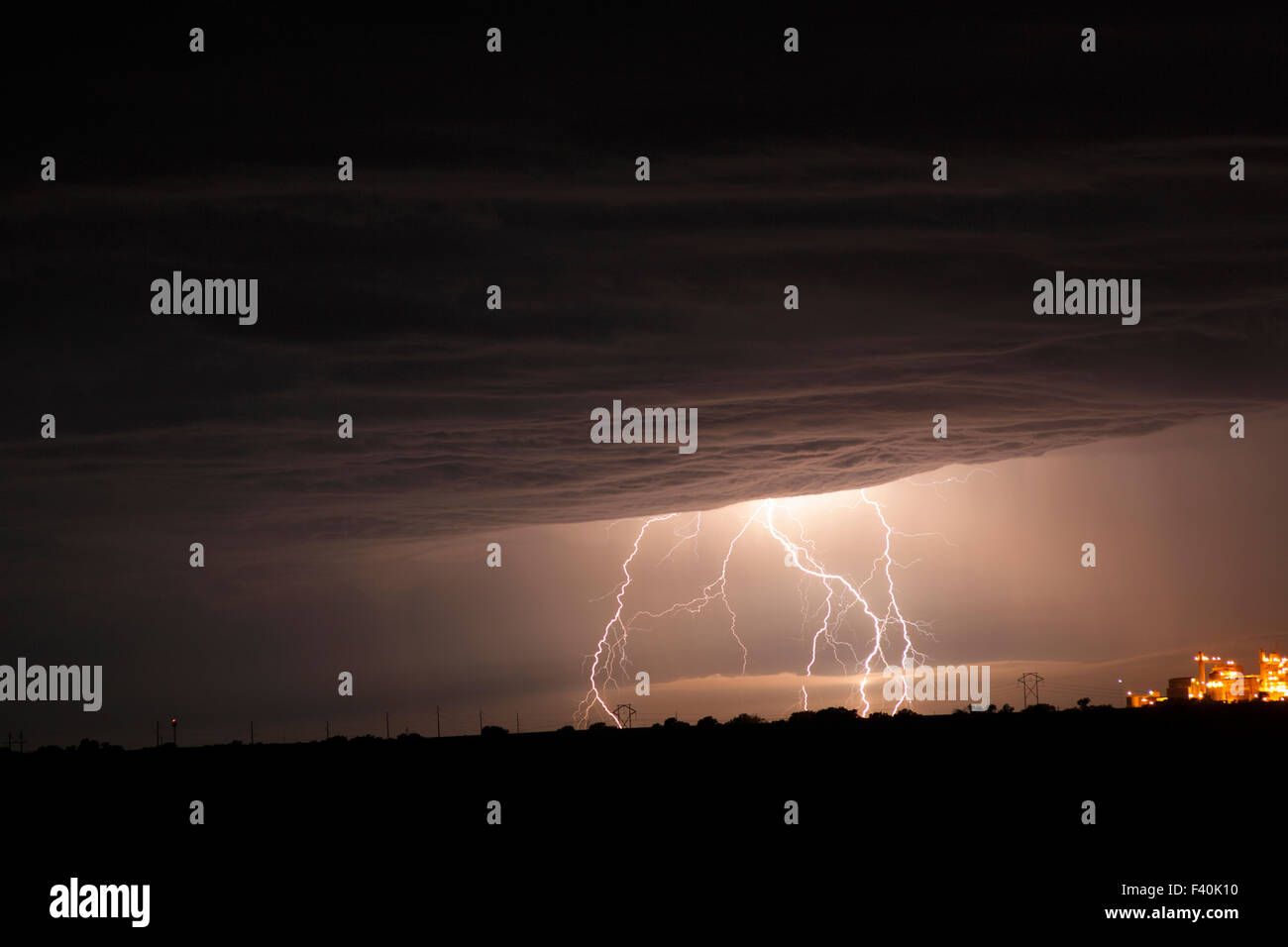 Several bolts of lightning strike near a power plant at night Stock ...