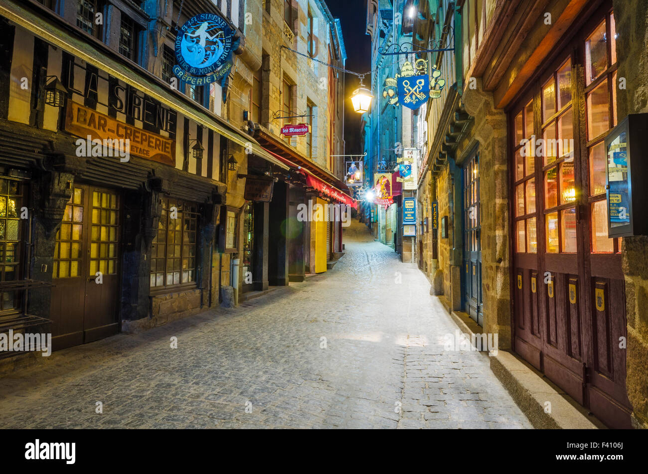 Shops and cobblestone street at night, Mont Saint-Michel, Normandy ...
