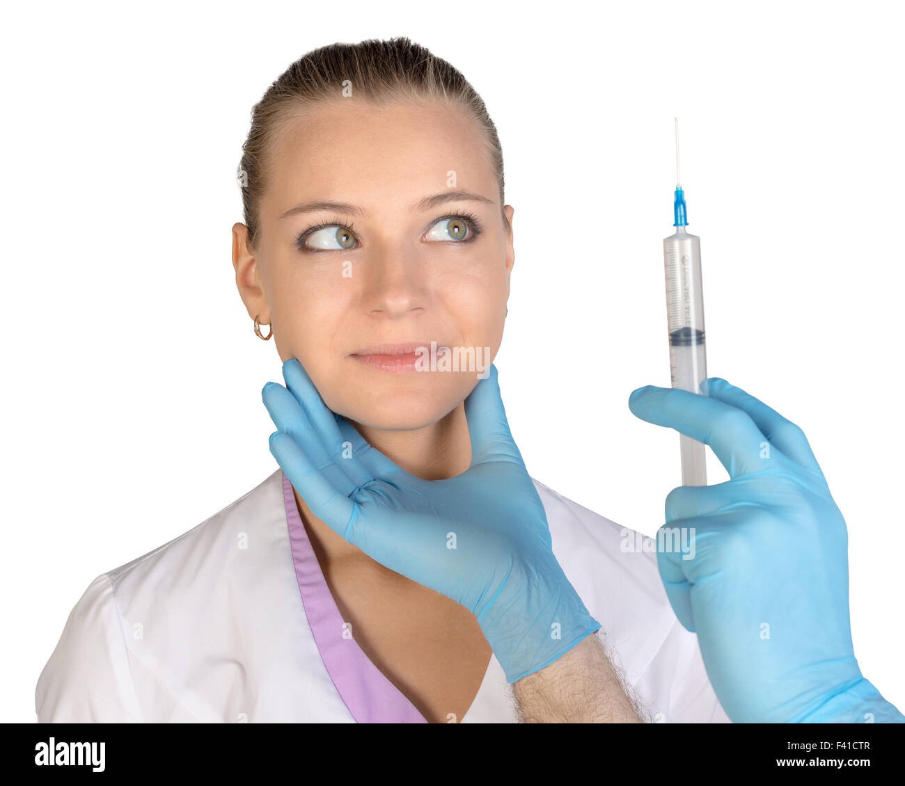 Surprised young woman looking at needle of syringe with an injection ...