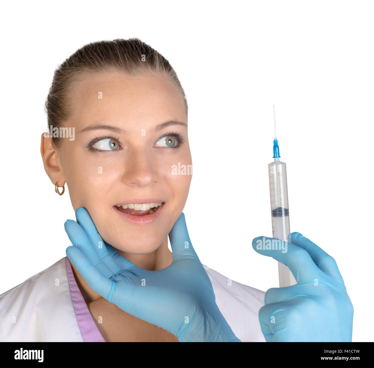 Surprised young woman looking at needle of syringe with an injection ...