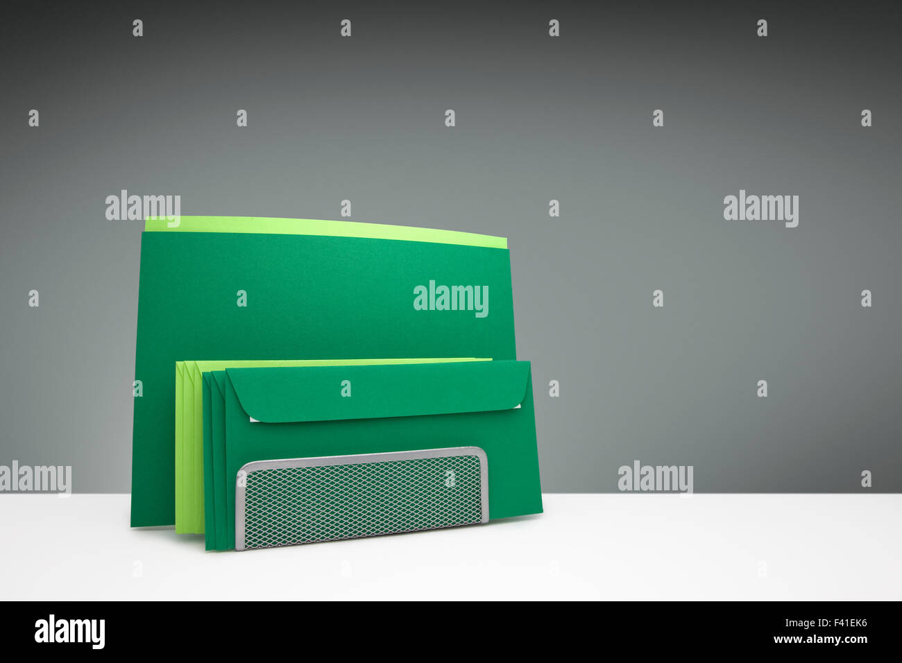 green paper and envelopes in a desktop letter holder Stock Photo - Alamy