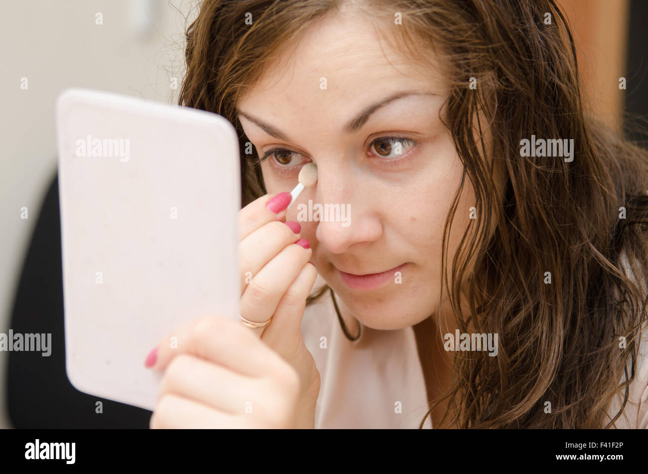Girl puts icing on the eyes Stock Photo - Alamy