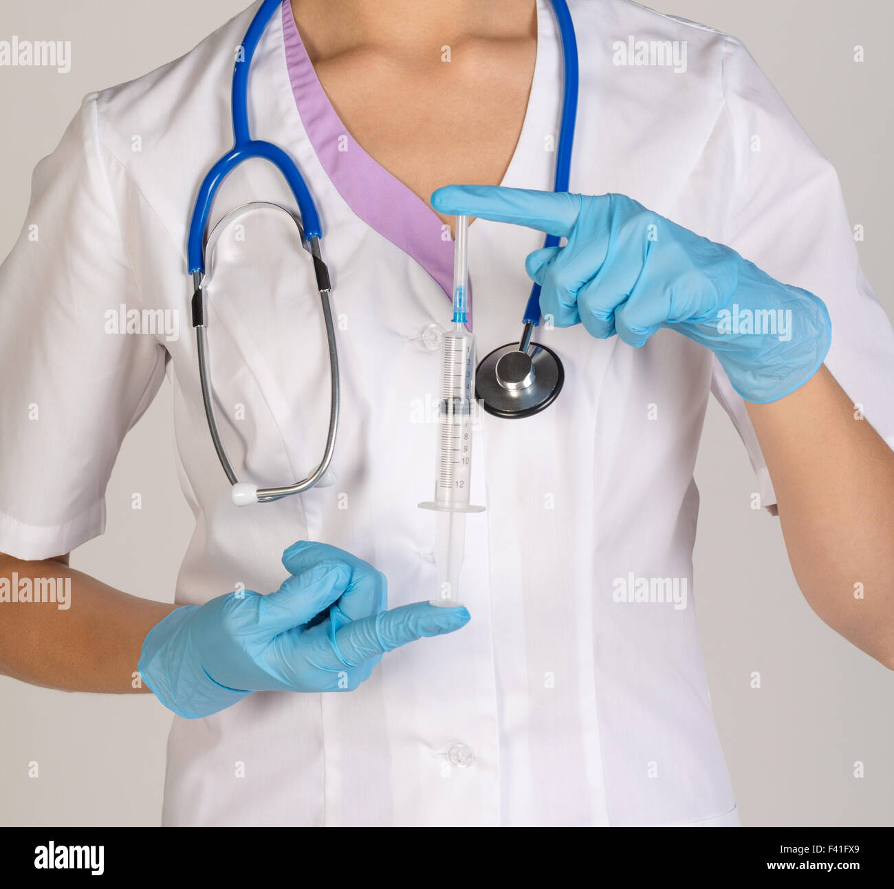 Woman doctor with stethoscope holding medical syringe Stock Photo - Alamy