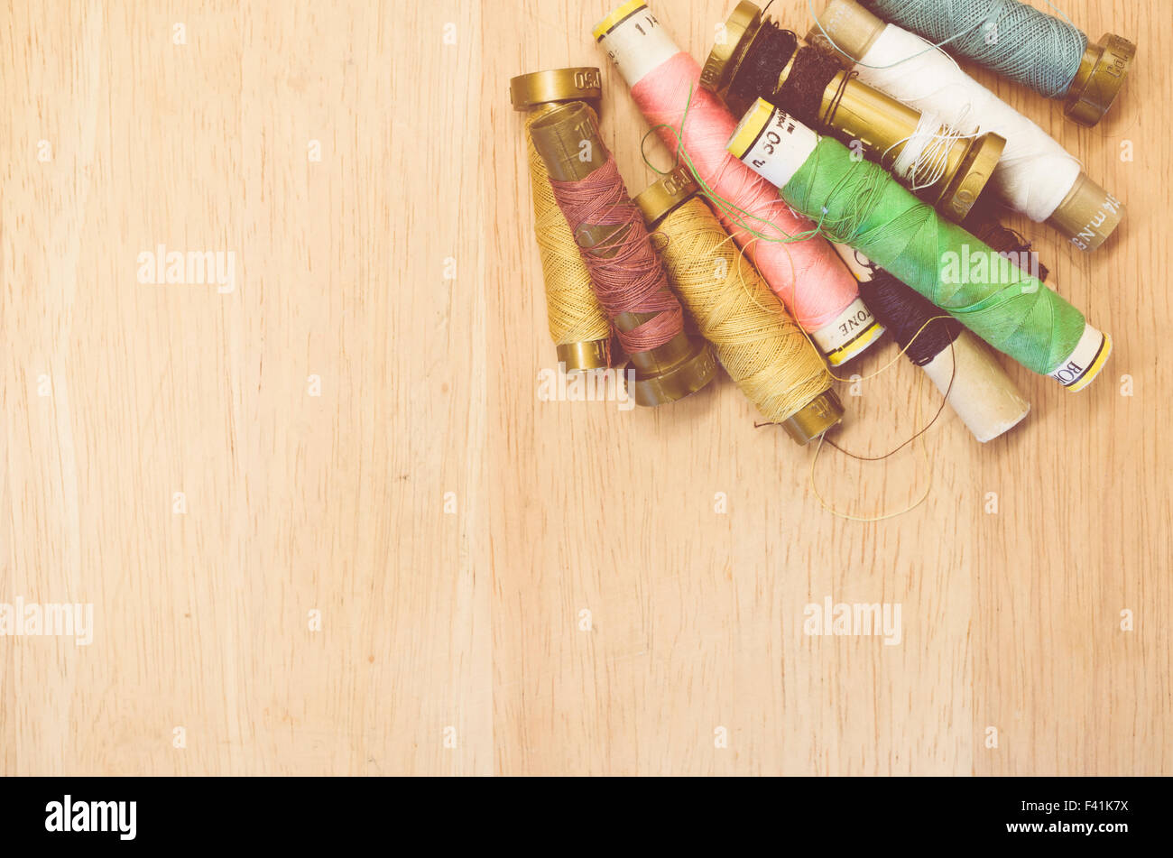 old sewing thread spools on natural wood background Stock Photo - Alamy