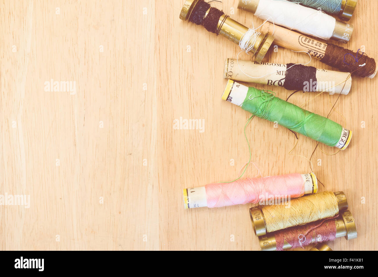 old sewing thread spools on natural wood background Stock Photo - Alamy
