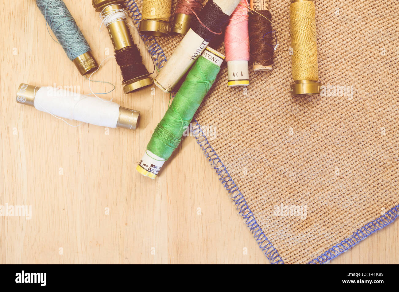 old sewing thread spools on burlap and wood background Stock Photo - Alamy