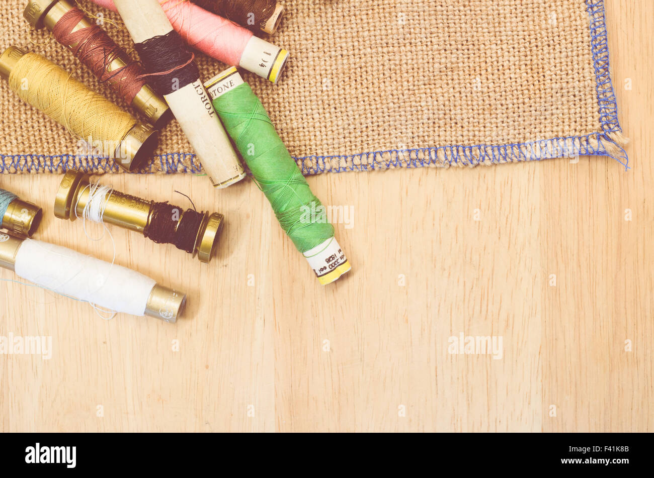 old sewing thread spools on burlap and wood background Stock Photo - Alamy