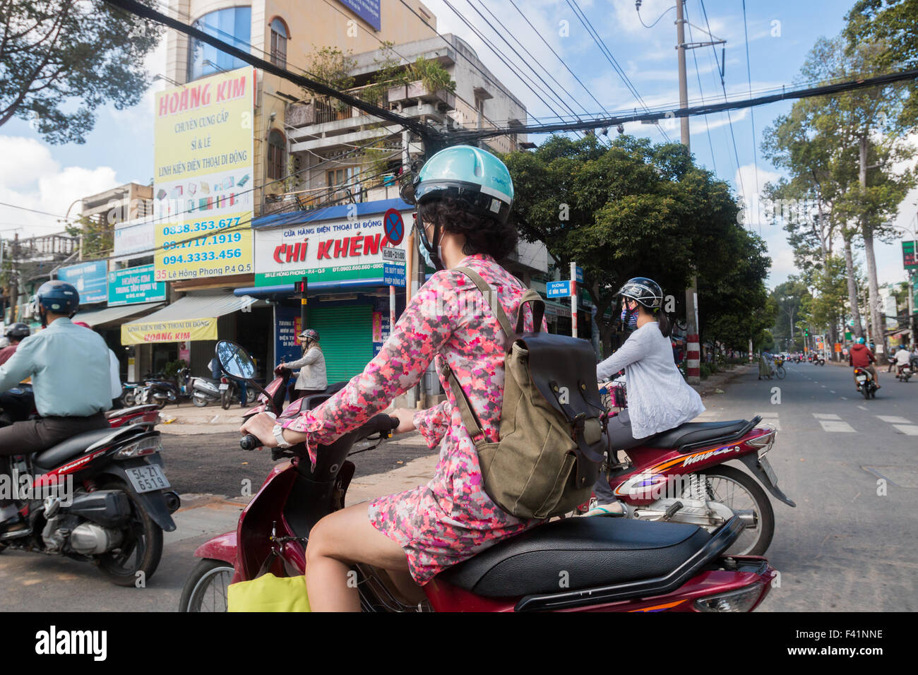 Vietnamese lady and male riders on their scooters motorcycles riding ...