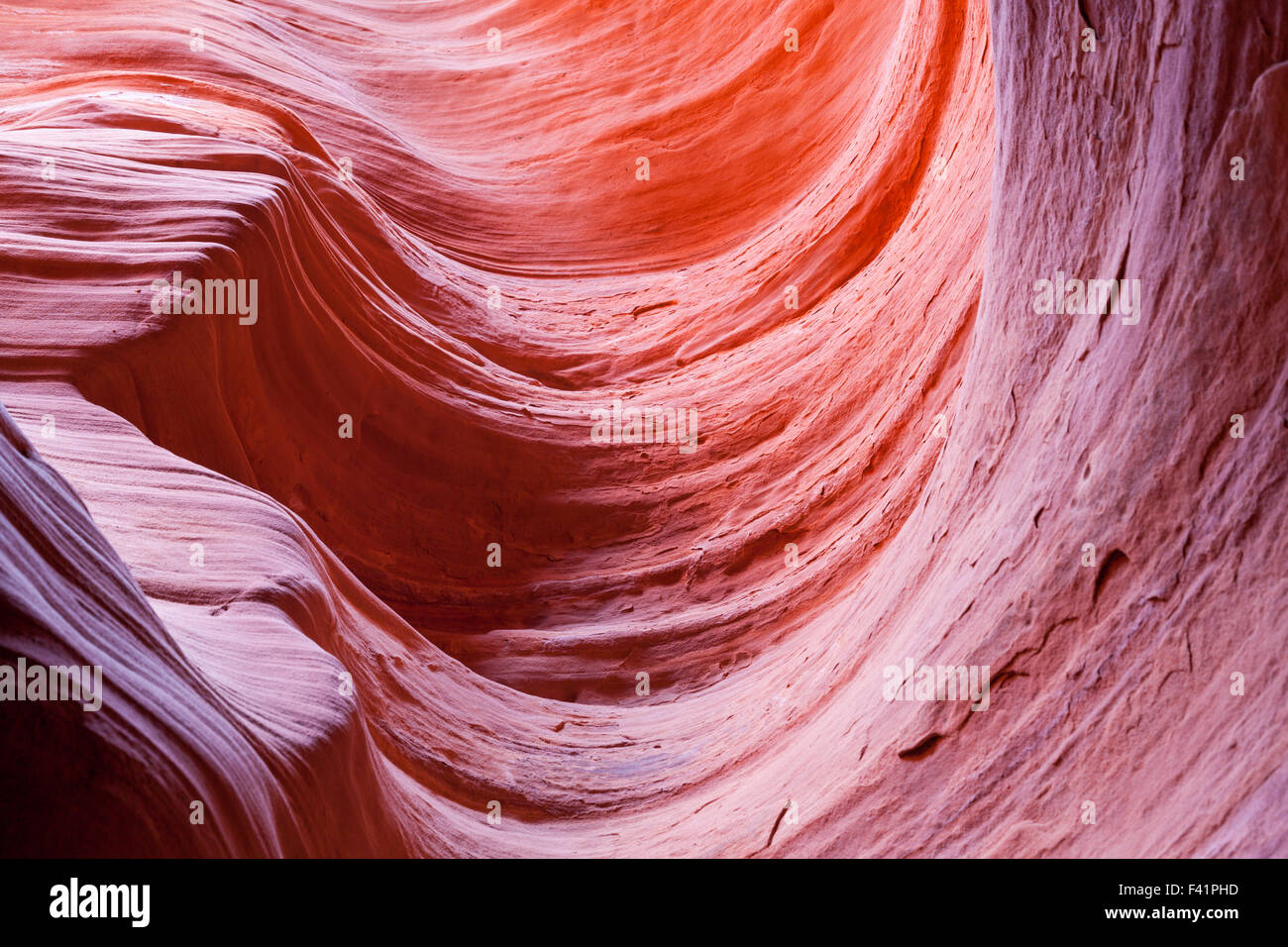 A close up of eroded ridges of sandstone walls of orange, pink , and ...