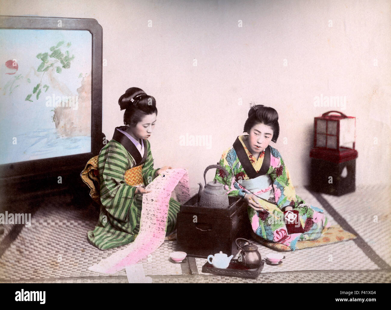 Two geishas reading and drinking tea, Japan Stock Photo - Alamy