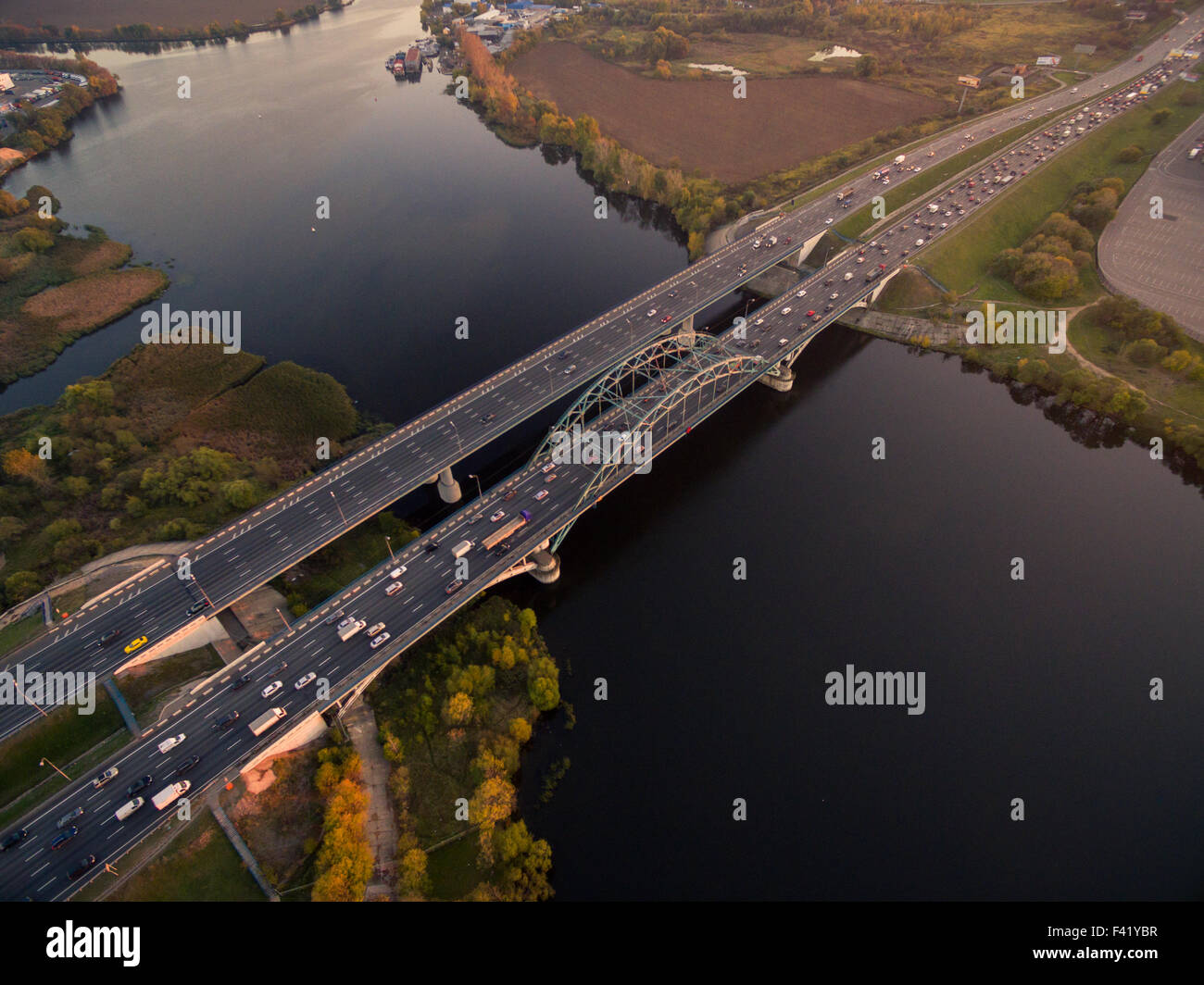 Bridge with lots of car traffic over the river at sunset Stock Photo ...