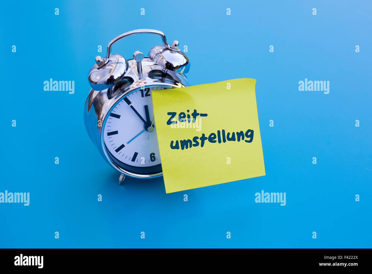 alarm clock on blue table with sticky note with german word ... alarm clock on blue table with sticky note with german word ...