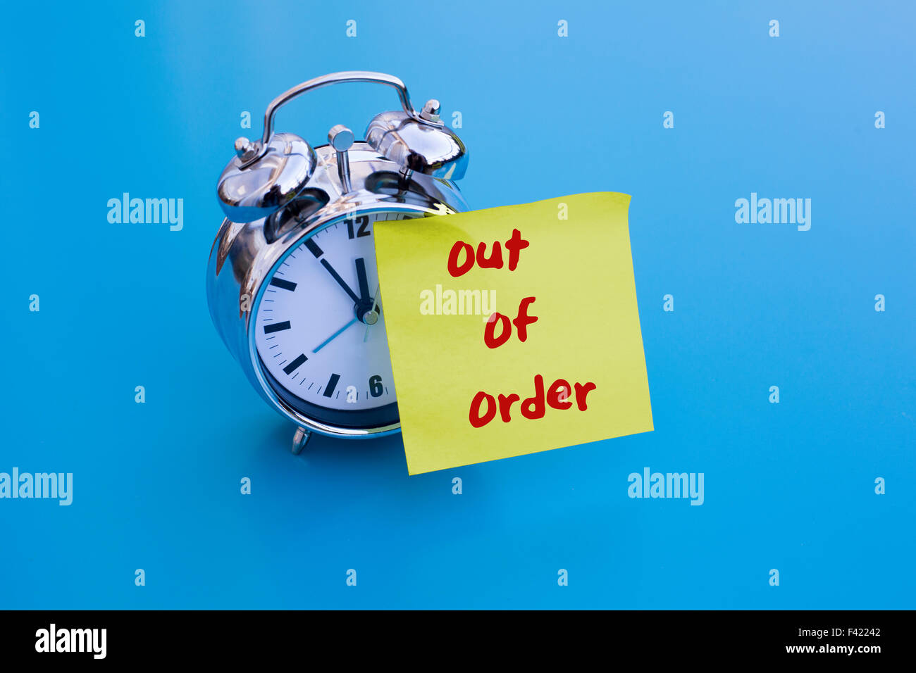 alarm clock on blue table with sticky note 'out of order' Stock Photo ...