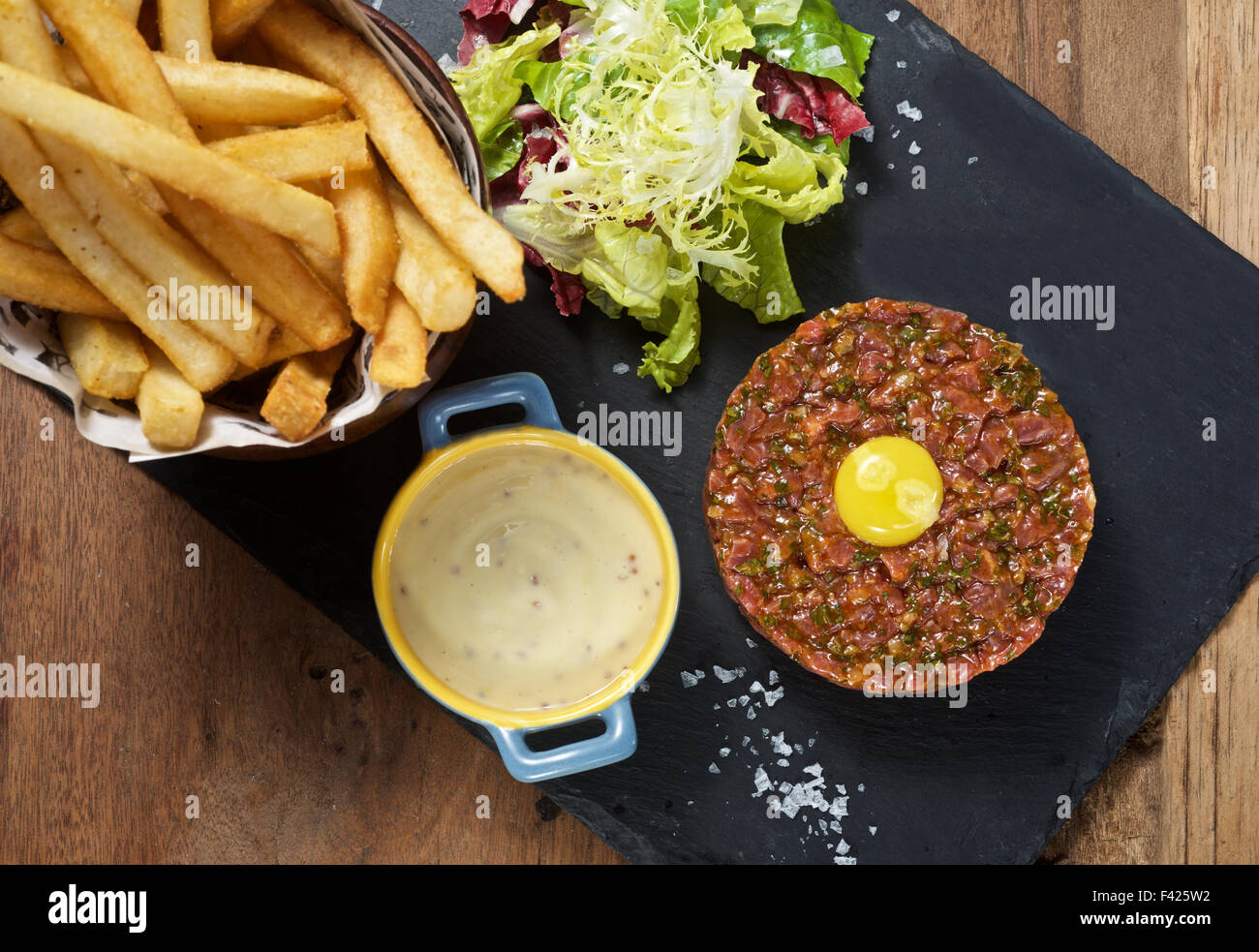 Tatar with egg yolk dish on black plate from top view Stock Photo - Alamy