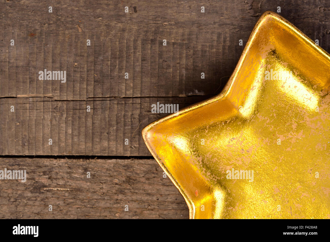 Empty golden star shaped bowl on a rustic wooden table with space for ...