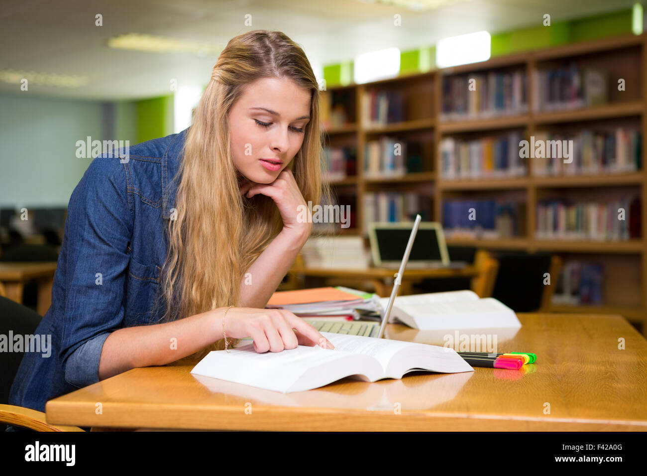 Student studying in the library with laptop Stock Photo - Alamy