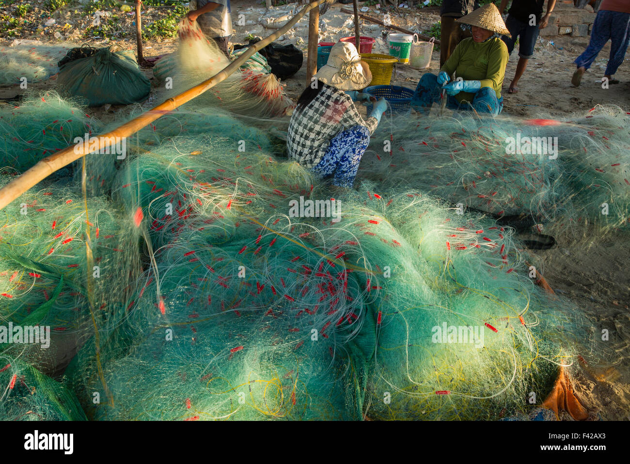 Woman repairing fishing nets hi-res stock photography and images - Alamy