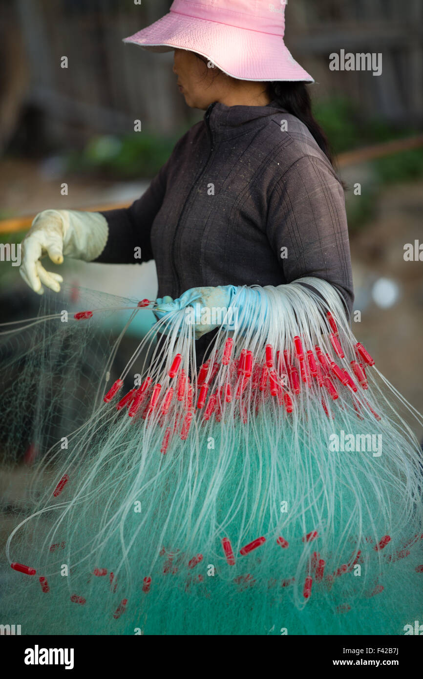 Woman repairing fishing nets hi-res stock photography and images - Alamy