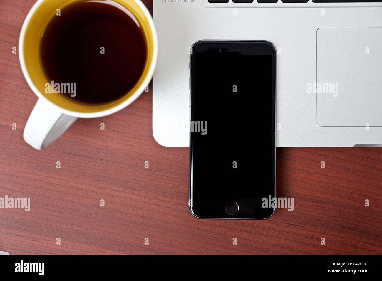 Coffee work table with mobile phone and laptop on a wooden pattern ...