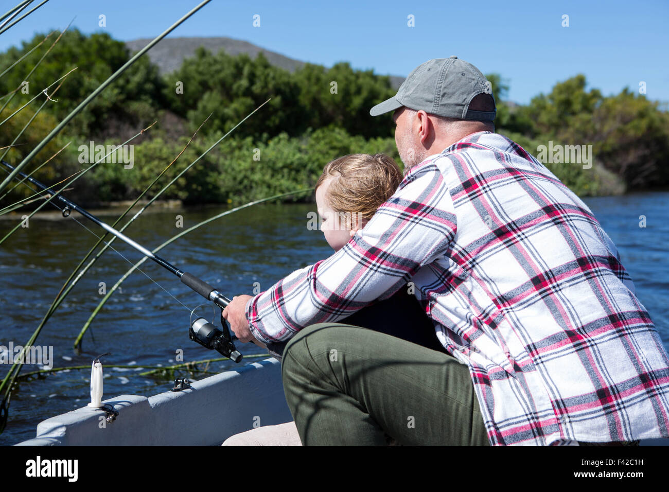 Happy man fishing with his son Stock Photo - Alamy