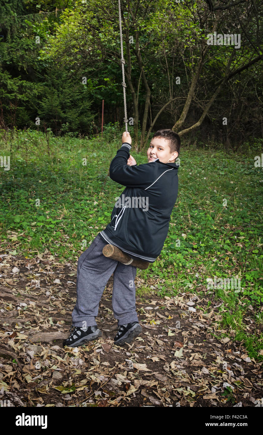 Young boy swing on the rope. Outdoor activity Stock Photo - Alamy