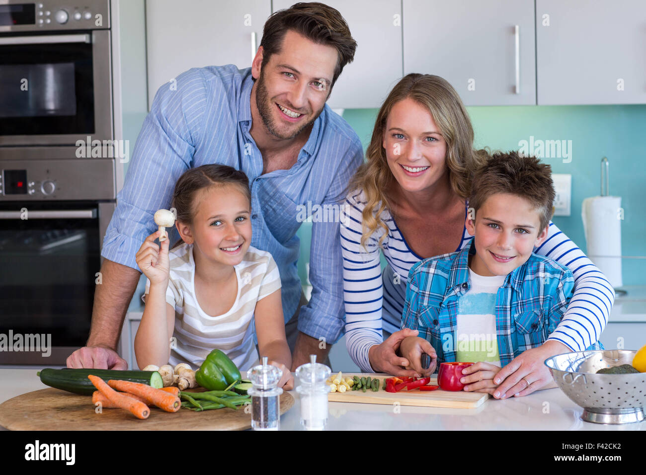 Happy family preparing vegetables together Stock Photo - Alamy