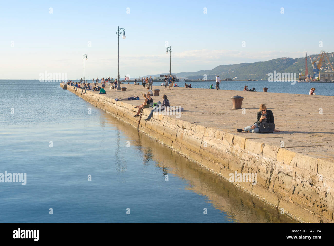 Trieste harbor, young people relax along the waterfront in Trieste ...