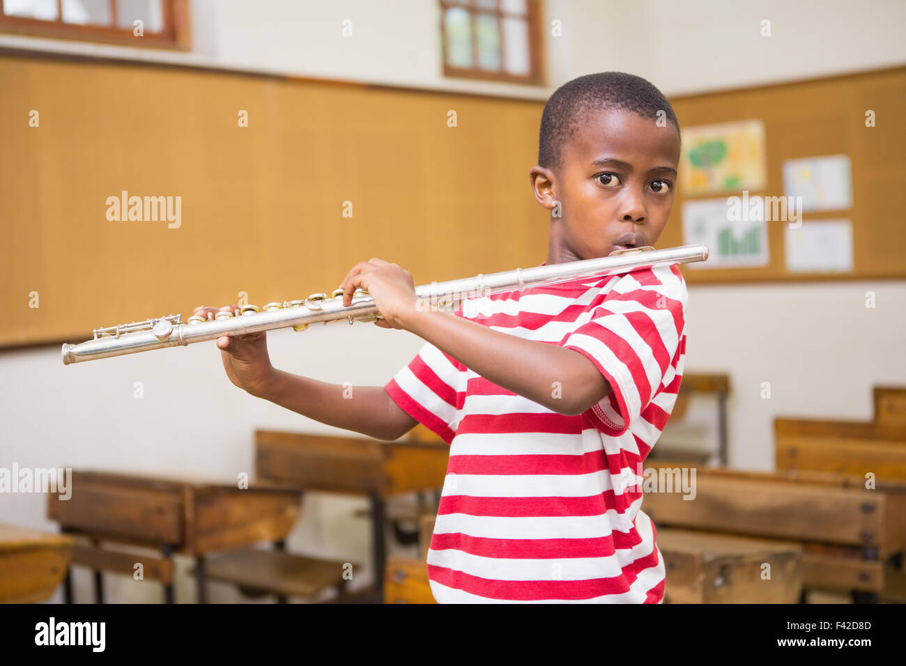 Cute pupil playing flute in classroom Stock Photo - Alamy