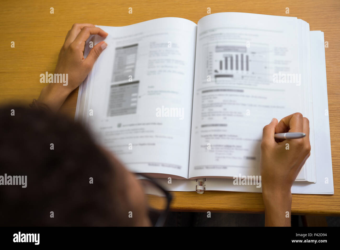 Student sitting in library writing Stock Photo - Alamy