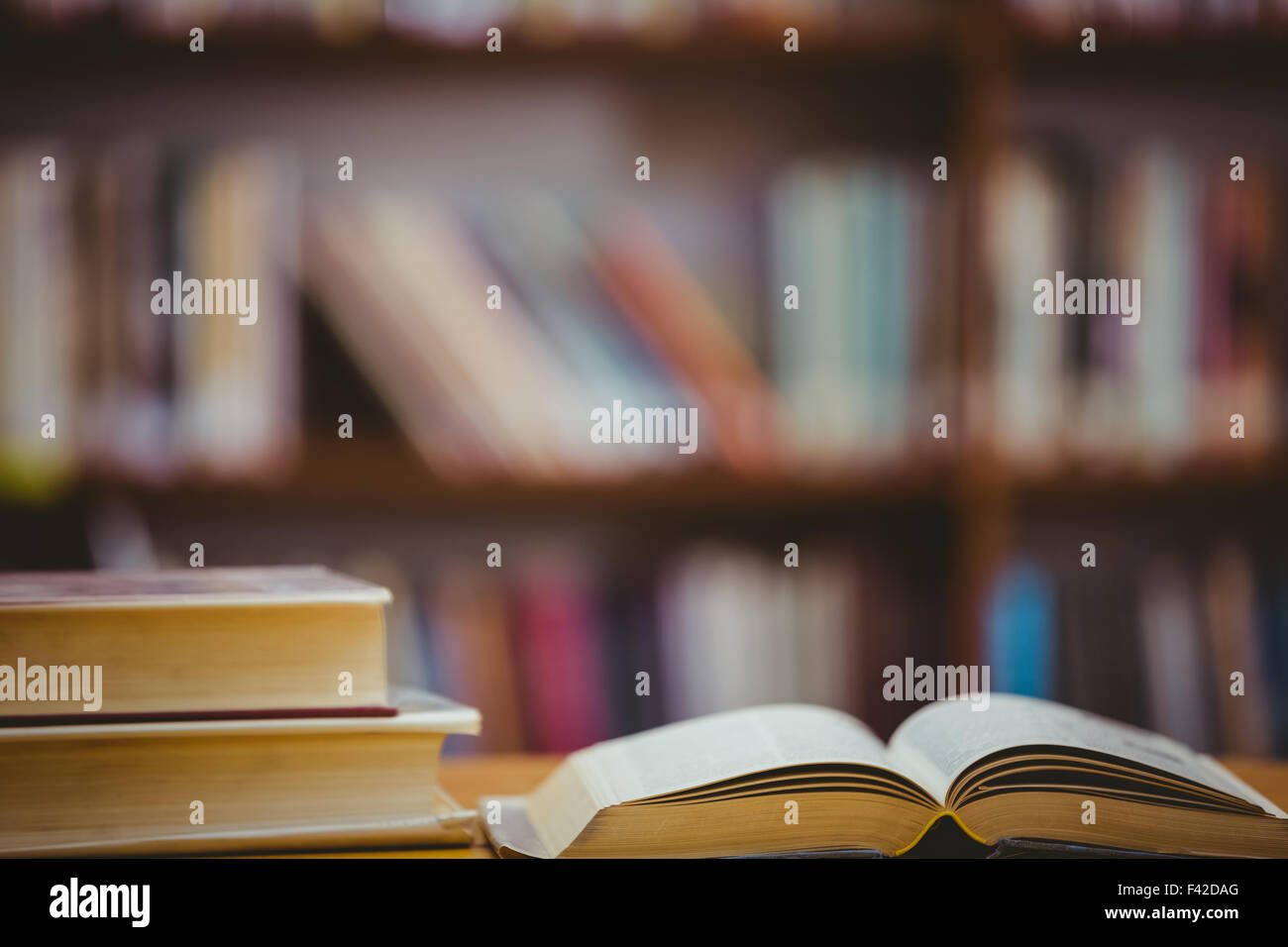 Books on desk in library Stock Photo - Alamy