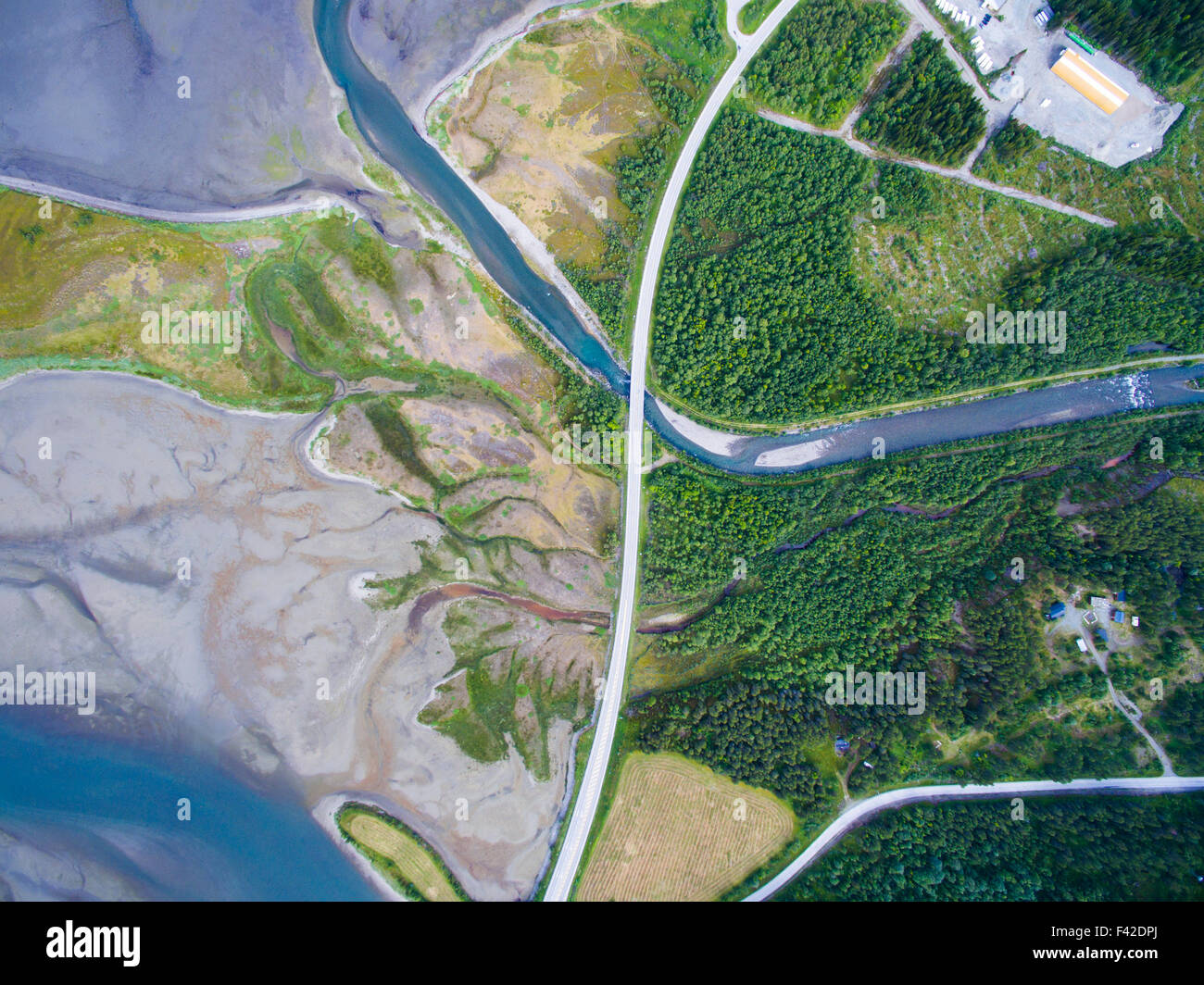 Top down aerial view of road passing through river delta in Norway ...